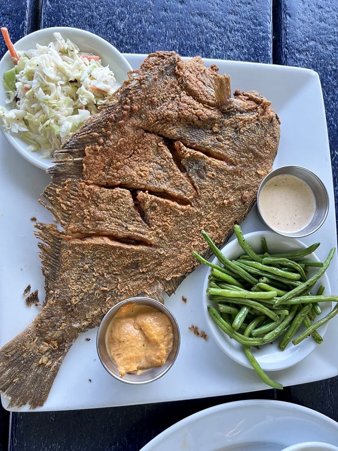This whole fried flounder isn't just a meal, it's a conversation piece—crispy, golden, and ready for its Instagram moment with green beans standing by.
