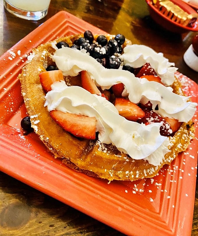 Berry-crowned waffle royalty that makes you question why people eat anything else for breakfast. That whipped cream isn't optional—it's essential.