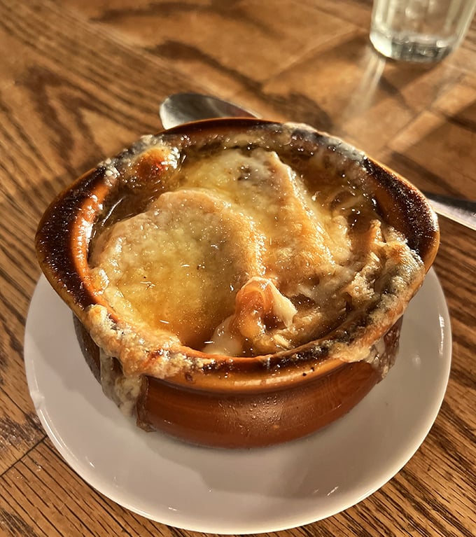 Not your average soup—this French onion arrives bubbling under a golden pastry dome. Breaking through is half the fun!