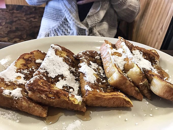 French toast that transforms humble bread into a morning masterpiece, dusted with powdered sugar like fresh Minnesota snow.