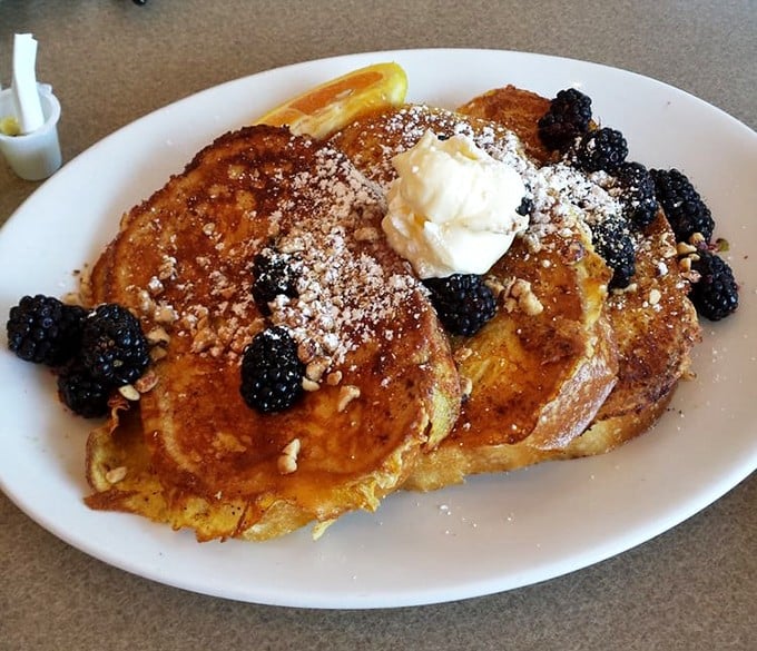 French toast that makes regular bread feel inadequate—crisp exterior, custardy interior, topped with fresh berries and a dusting of powdered sugar.