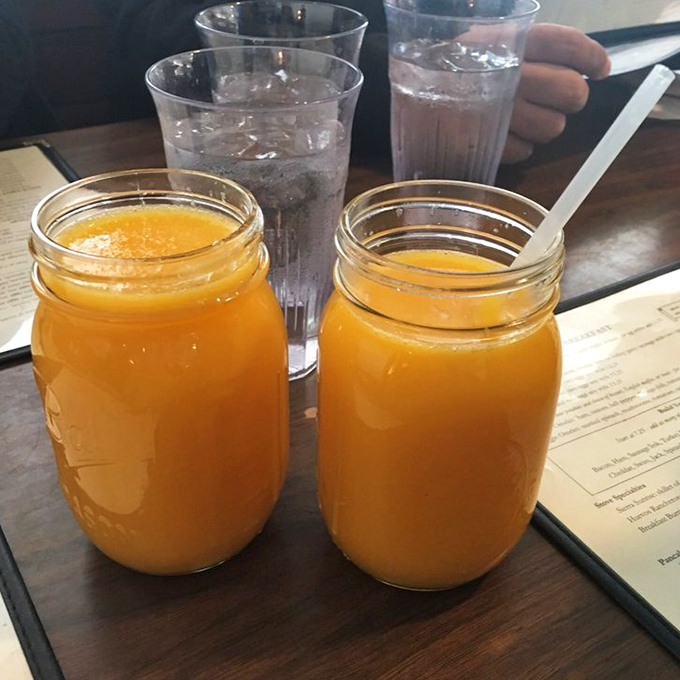 Fresh-squeezed orange juice served in Mason jars—because when you're doing things right, even the container needs to telegraph "this isn't from concentrate, friend."