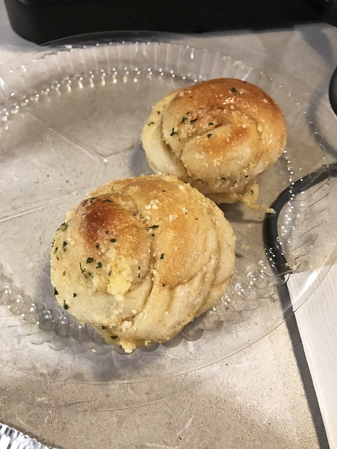 Golden garlic knots that look like edible clouds dusted with herbs – resistance is absolutely futile here.