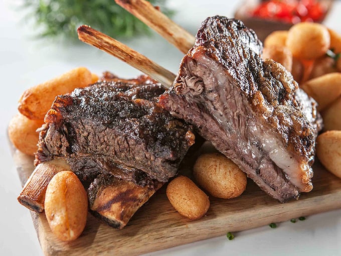 These beef ribs don't just fall off the bone—they practically leap onto your fork, begging to be devoured alongside those plump little cheese rolls.