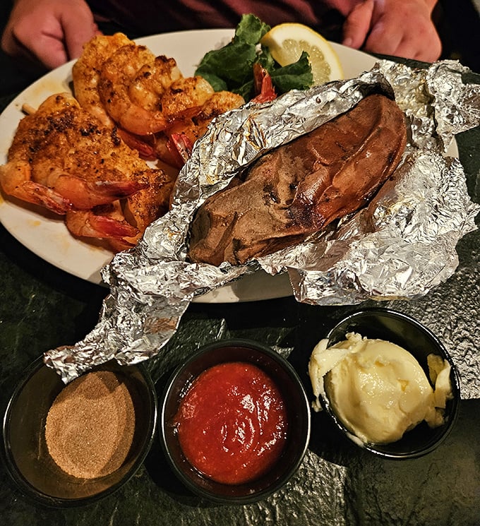 Grilled shrimp and a foil-wrapped potato—a simple combination elevated to art form through perfect seasoning and timing, like a culinary haiku.