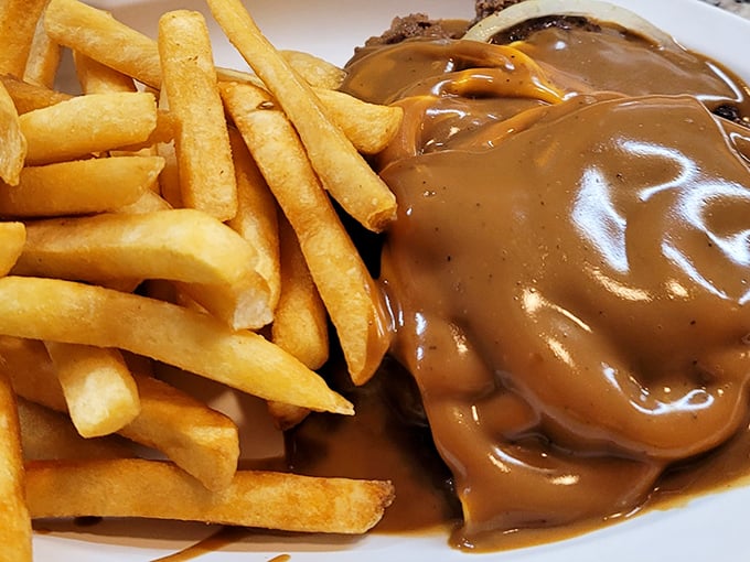 Hamburger steak swimming in rich gravy alongside golden fries—comfort food that whispers "everything's going to be alright" with every savory bite.