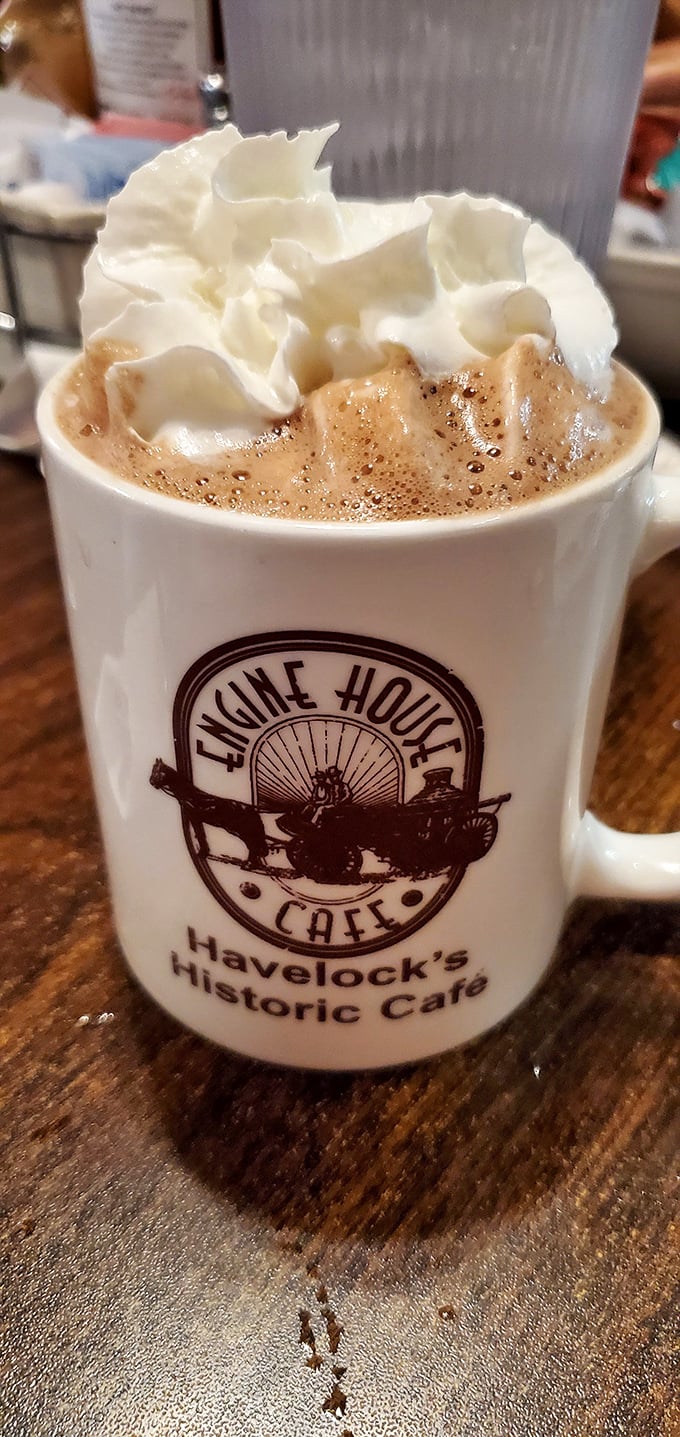 Hot chocolate topped with whipped cream in a café mug – simple pleasures that remind you why breakfast matters most.
