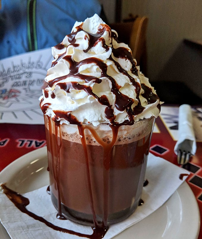 This hot chocolate isn't just a beverage – it's a towering monument to whipped cream and chocolate drizzle decadence.
