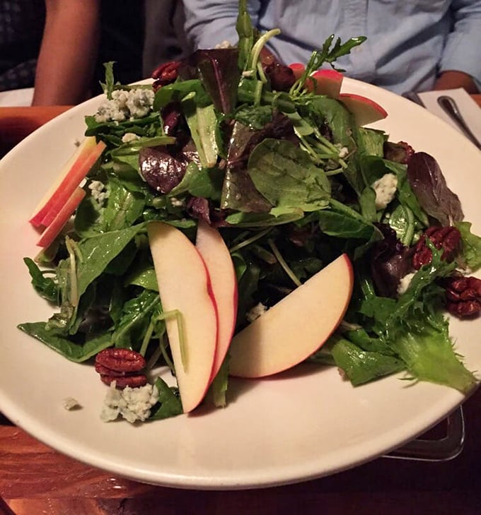 The house salad offers a refreshing counterpoint to pizza indulgence—crisp greens, seasonal fruit, and a vinaigrette that means business.
