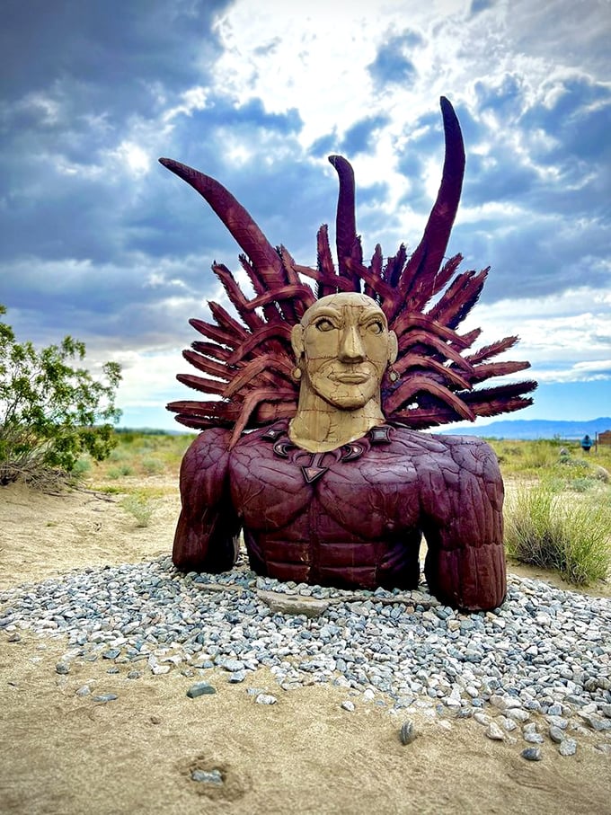 Not your average garden statue! This indigenous figure with dramatic headdress emerges from the desert floor like a vision from another time.