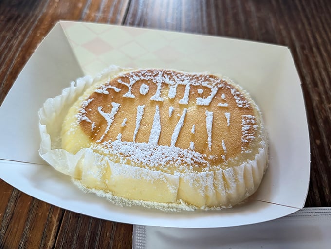 Not just dessert, but edible art! The Japanese cheesecake wears its "Soupa Saiyan" branding like a superhero emblem, dusted with powdered sugar.