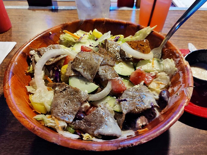 A wooden bowl cradles this hearty salad—the token vegetable option that somehow still feels indulgent. Guilt, meet pleasure.