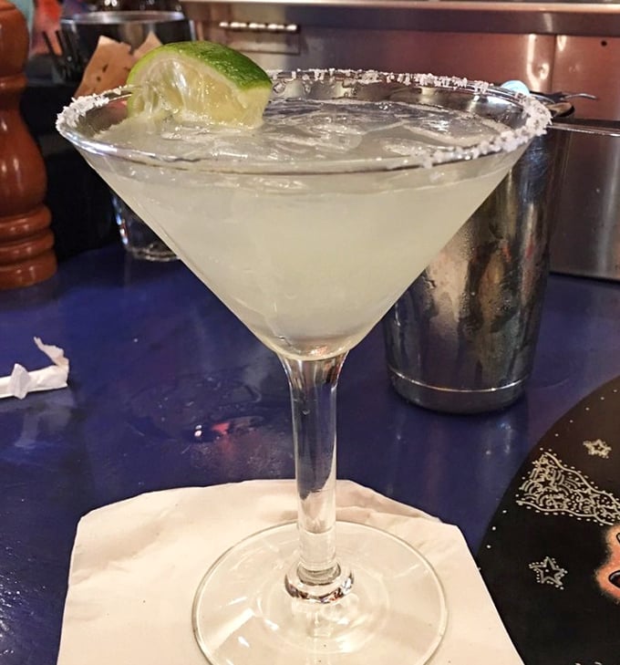 The perfect margarita—salt-rimmed, crystal clear, with that lime perched on the edge like it's enjoying the view too.