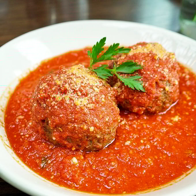 These aren't just meatballs—they're edible monuments to Italian-American cuisine, swimming in a sea of red sauce that demands to be sopped up.