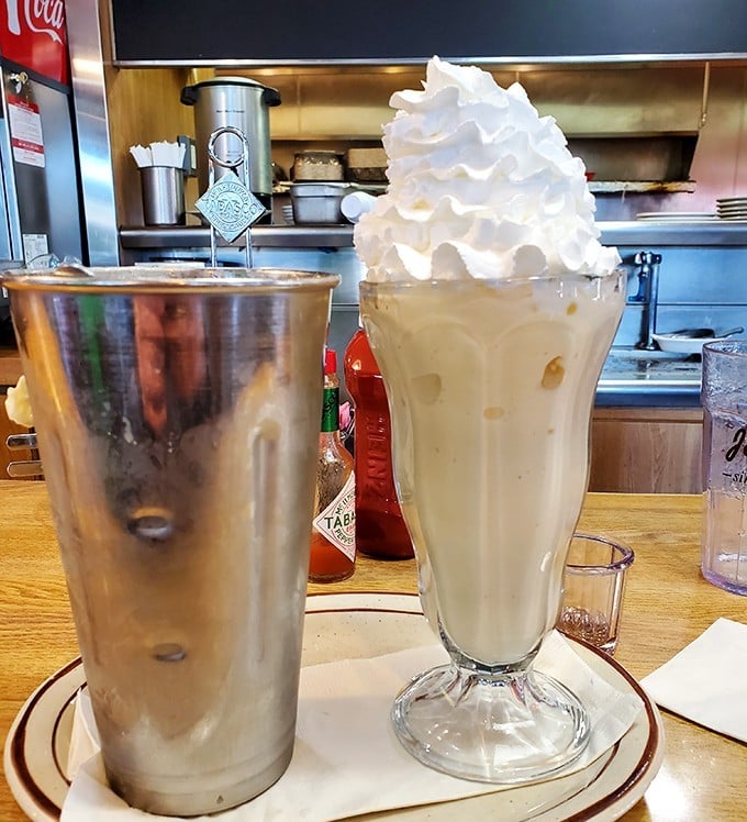 That milkshake isn't just thick – it's contemplating a career in architecture with that towering whipped cream spire.