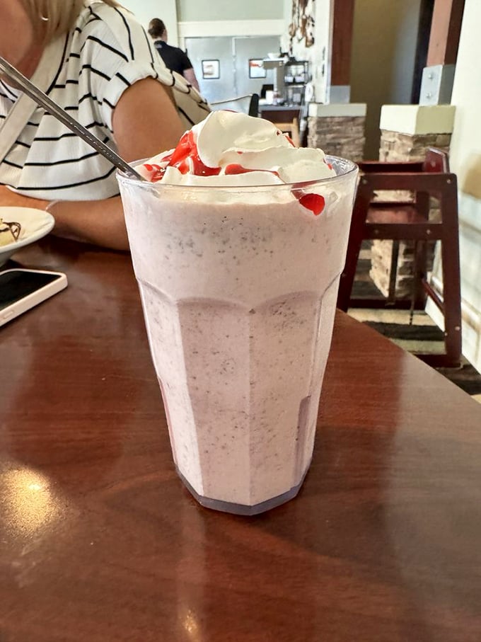 This isn't just a milkshake; it's dessert architecture topped with whipped cream and cherries that demands to be photographed before consumed.
