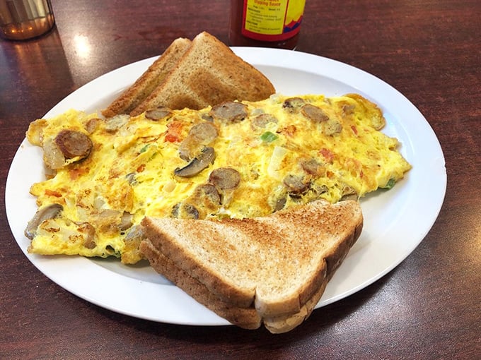 This isn't just an omelet—it's a fluffy yellow canvas painted with mushrooms and perfectly toasted bread standing guard on either side.