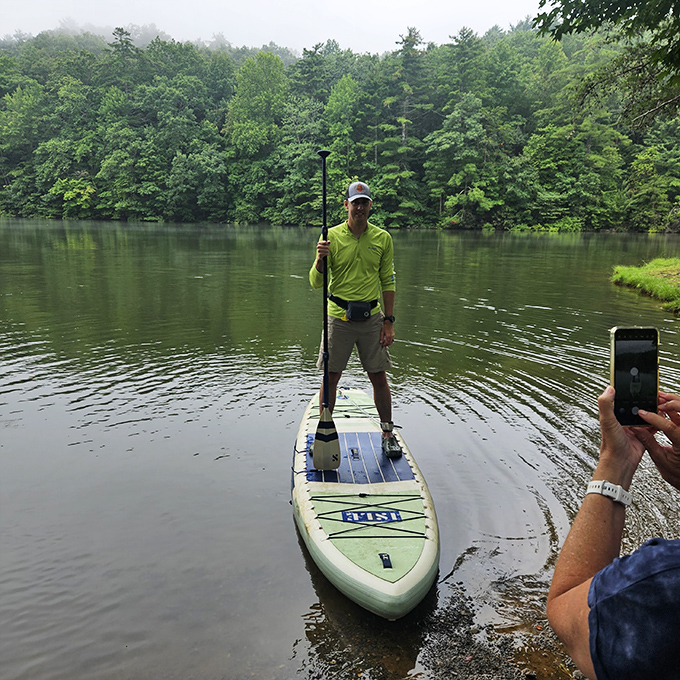 Stand-up paddleboarding on glassy mountain waters – where serenity meets exercise and nobody minds if you fall in occasionally.