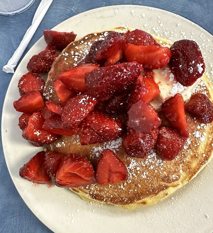 These pancakes, crowned with fresh strawberries and a dusting of powdered sugar, aren't just breakfast – they're edible sunshine on a plate.