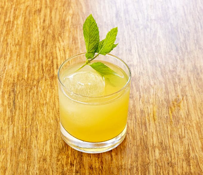 Sunshine in a glass! This bright Peach Sour cocktail, garnished with fresh mint, offers the perfect balance of sweet and tangy—like summer decided to stick around for dinner.