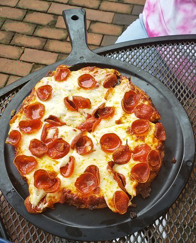 A cast-iron skillet pizza with pepperoni that curls into perfect little flavor cups – proof that sometimes the simplest dishes deliver the most satisfaction.