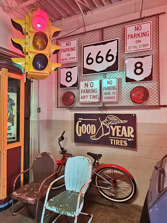 Traffic lights, highway signs, and weathered metal chairs create a roadside Americana vignette that practically smells like a 1950s gas station.