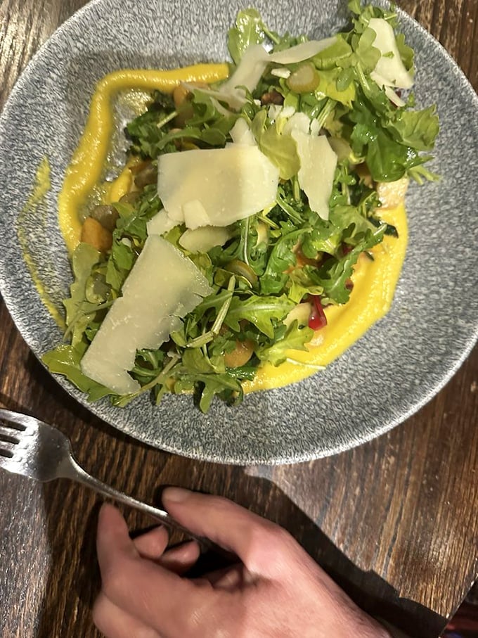 Fresh greens with shaved parmesan on a vibrant sauce—proof that salads don't have to be punishment between steak dinners.