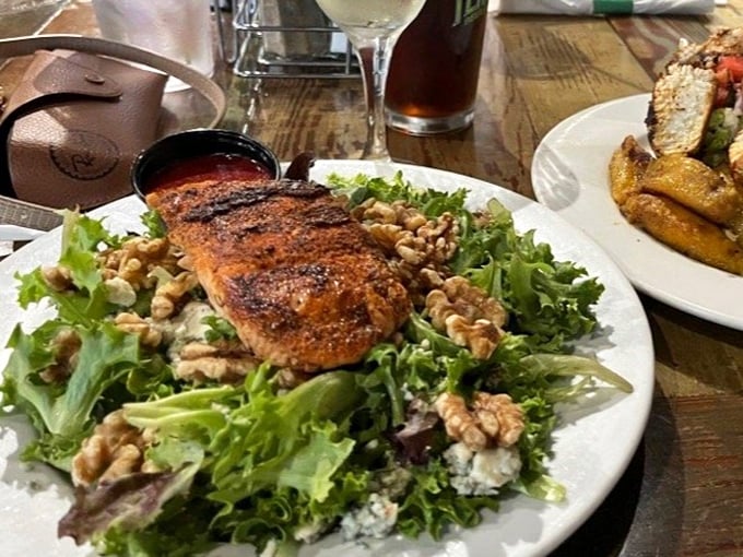 A salmon salad that makes eating greens feel less like virtue and more like indulgence—the leafy equivalent of finding money in your pocket.