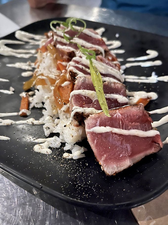 Seared tuna that's dressed better than most wedding guests, with a sauce drizzle that belongs in the abstract art museum.