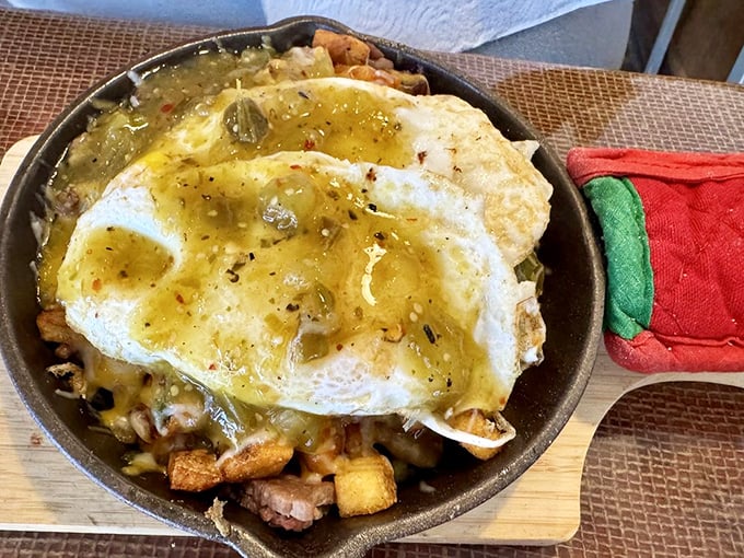 A skillet breakfast that sizzles with personality—sunny eggs crowning a kingdom of potatoes and meat in their cast iron throne. 