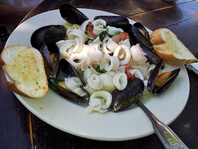 The seafood pasta arrives like an oceanic treasure chest—mussels, calamari, and pasta swimming in a broth worth drinking directly from the bowl.