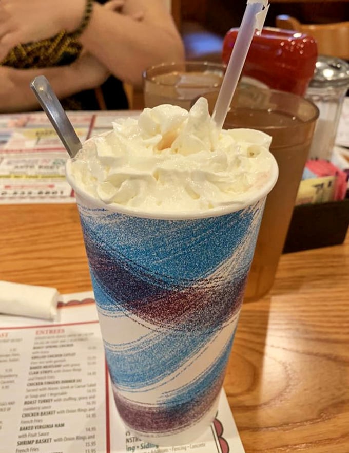 A milkshake dressed in its Sunday best. That whipped cream crown isn't just decoration—it's a dairy kingdom's royal headwear.