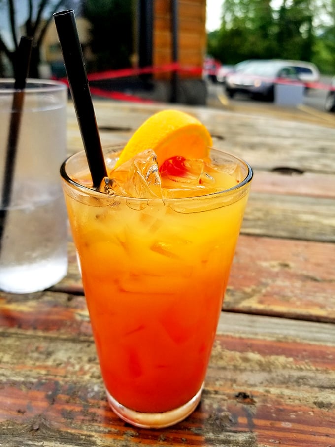 A sunset in a glass – this tequila sunrise sits on a weathered wooden table, promising good times ahead.