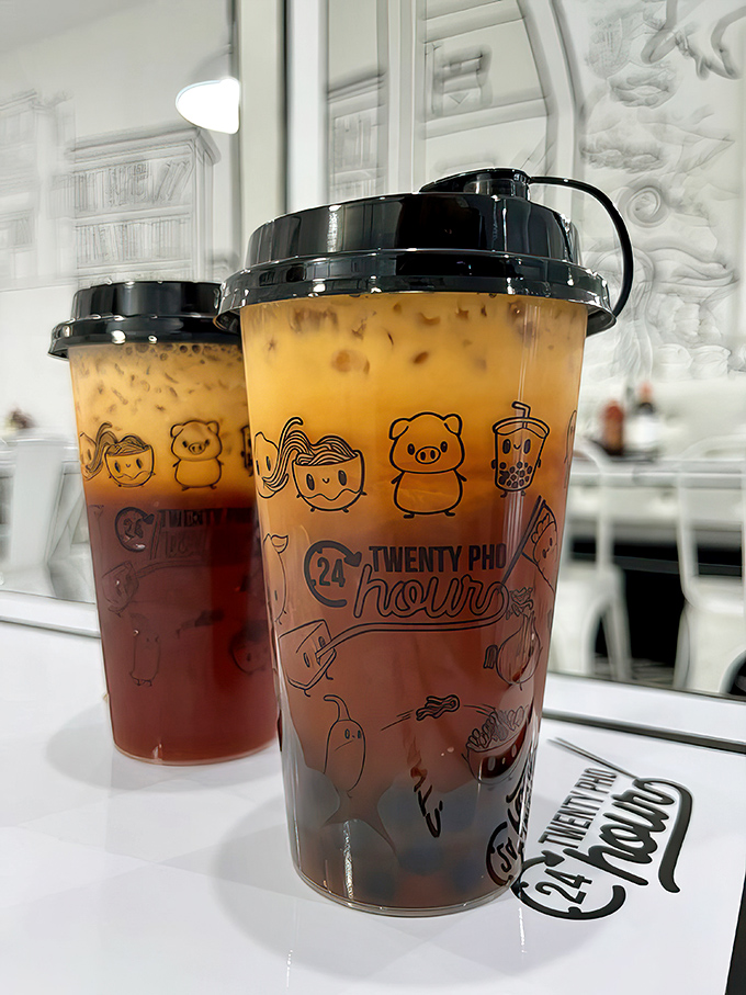 Thai tea in custom cups—where the layers aren't just for show. The perfect sweet counterpoint to spicy dishes.