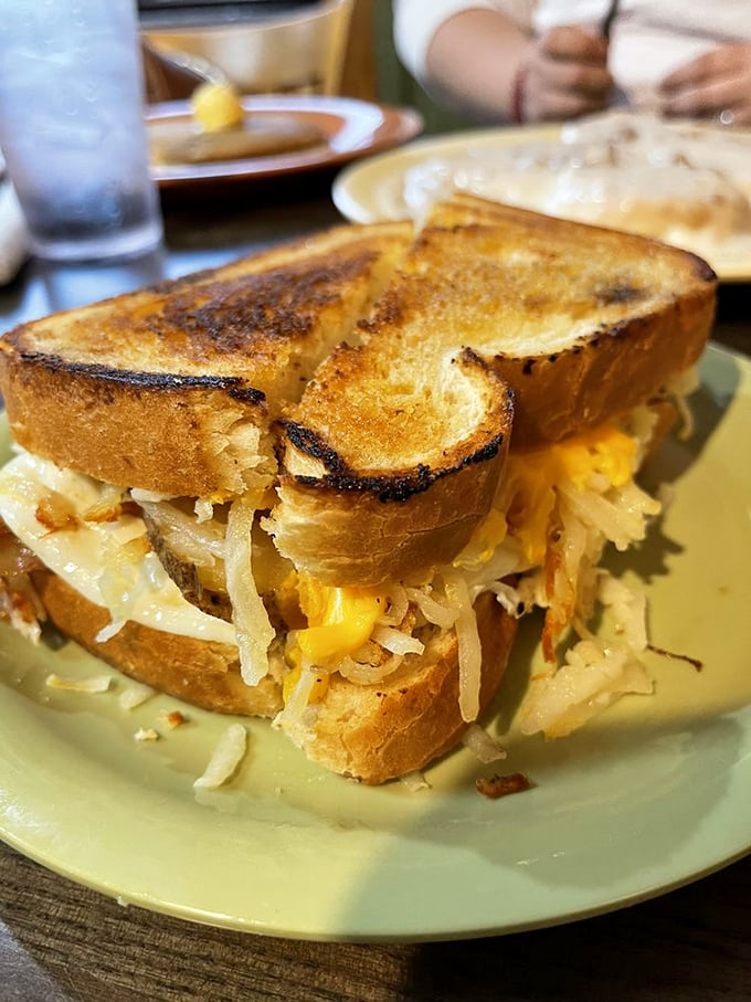 Breakfast sandwiches reach new heights when golden toast embraces eggs, melted cheese, and hashbrowns in a morning masterpiece that demands two hands.