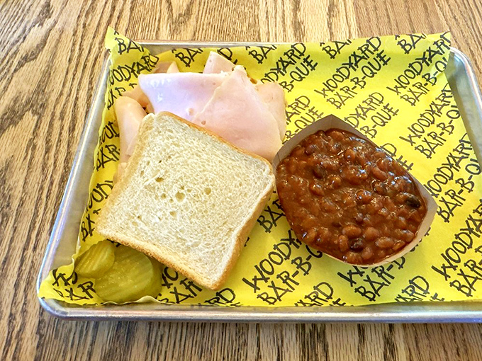 A simple turkey sandwich elevated to art form through the magic of smoke. Those baked beans alongside aren't just a side—they're a revelation.