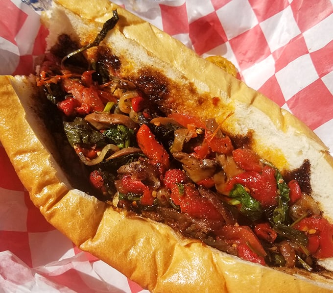 A symphony of colors and textures – this sandwich bursts with roasted peppers and savory fillings nestled in a perfectly crusty roll.