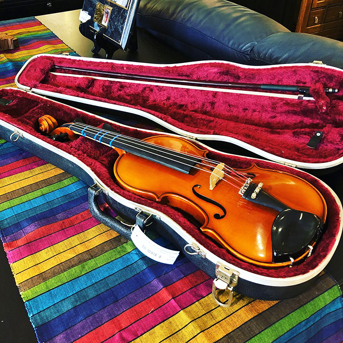 A violin waiting for its next concerto. Musical instruments here are like rescue pets—they just need someone to take them home and love them again.