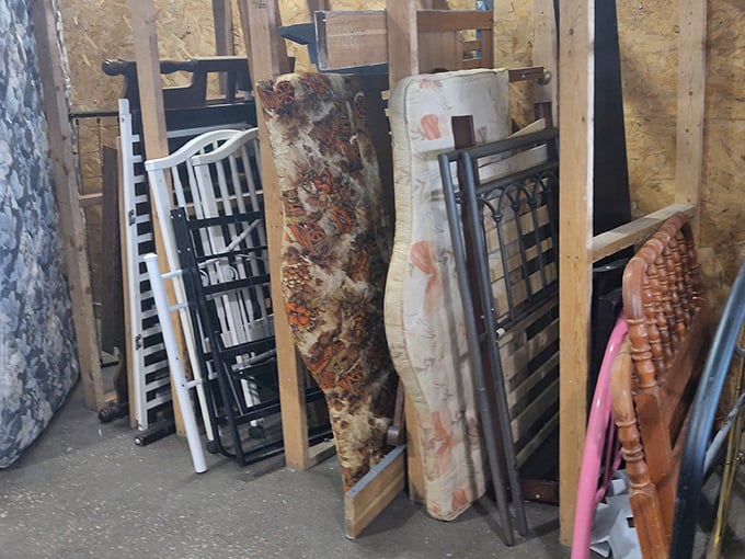 The furniture graveyard: headboards and bed frames lean like dominos, waiting for someone to envision their potential in a Pinterest-worthy bedroom makeover.