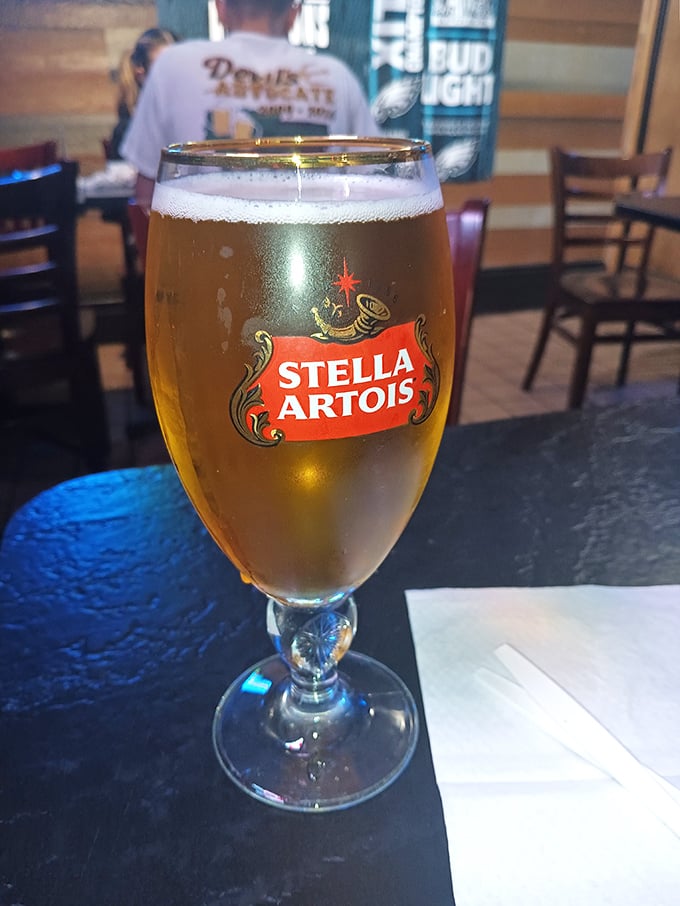 A golden chalice of Stella Artois stands ready to wash down your sandwich—because even royalty needs something to drink.