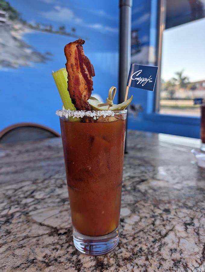 This isn't just a Bloody Mary—it's breakfast in a glass with a bacon strip exclamation point.