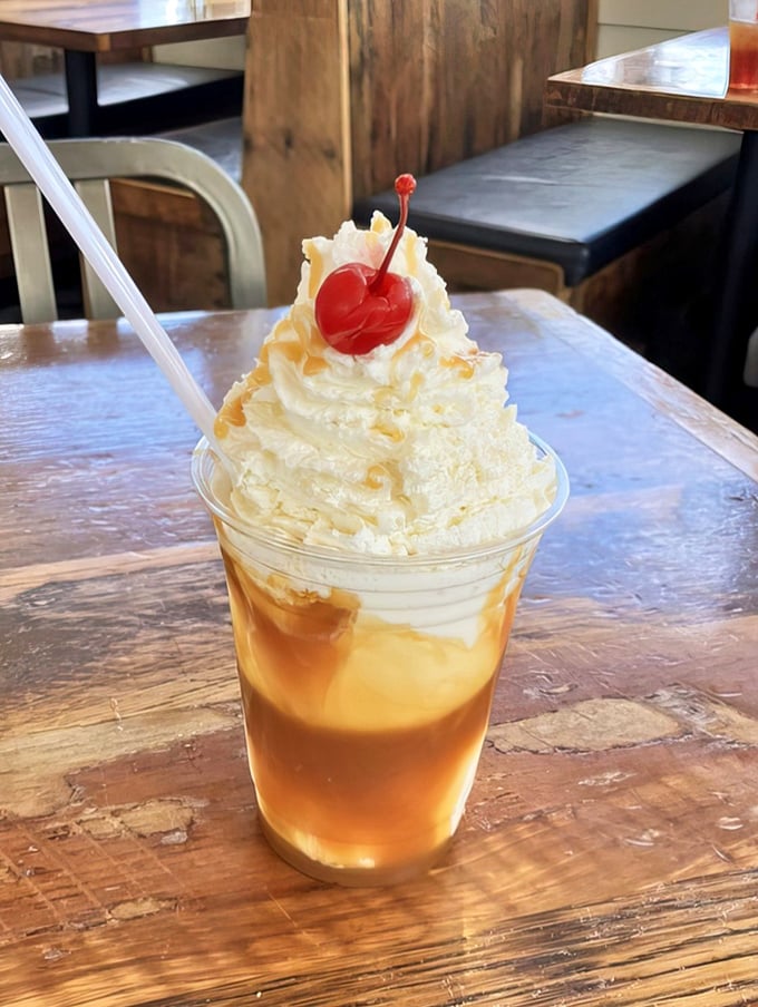 A caramel sundae topped with whipped cream and a cherry—dessert architecture that belongs in the Louvre of frozen treats.