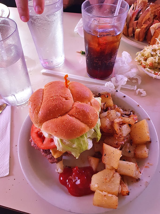 This isn't just lunch—it's a symphony of textures where juicy burger meets crisp lettuce and home fries play the perfect supporting role.