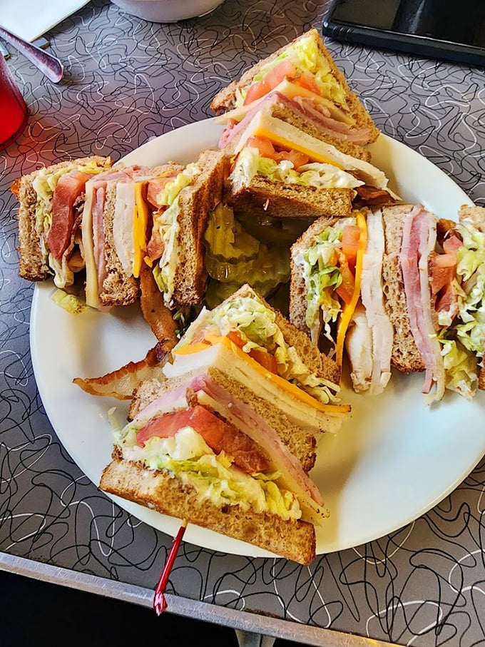 This club sandwich isn't stacked – it's architected, a towering monument to the art of sandwich engineering that dares you to unhinge your jaw.