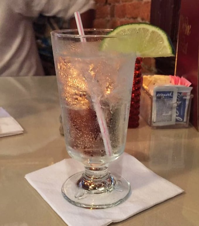 A properly garnished cocktail catching the light just right—like liquid jewelry with that lime wedge crown. Refreshment that doubles as eye candy.