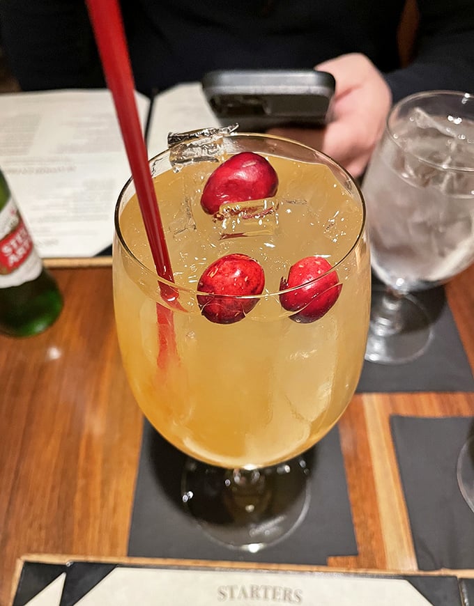 This cocktail isn't just a drink, it's liquid sunshine garnished with cranberries—the kind of beverage that makes you forget checking your phone exists.