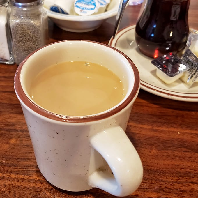 The humble white mug—civilization's most perfect delivery system for caffeine. In diners like this, refills arrive before you realize you need them.