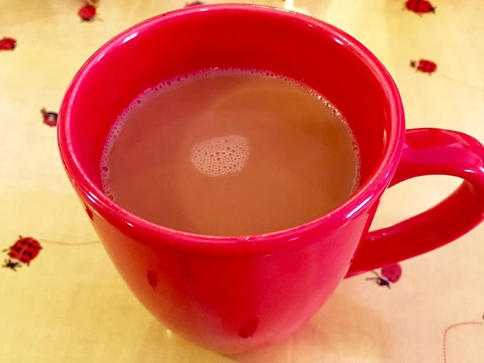 That red mug isn't just holding coffee—it's cradling liquid motivation, the essential fuel for conversations that meander like the Mississippi River.