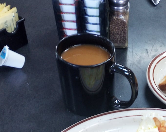 That classic black diner mug isn't just holding coffee—it's cradling liquid motivation that's fueled American mornings since time immemorial.