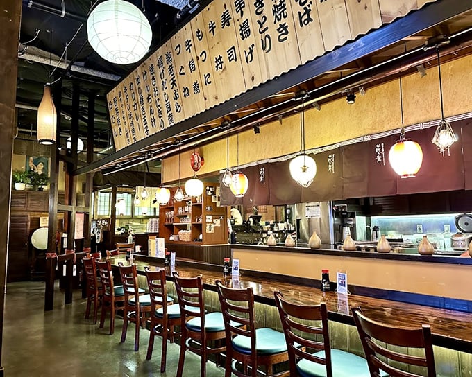 The counter seating offers dinner and a show—chefs orchestrating a culinary symphony while lanterns cast that perfect "everyone looks good" lighting.